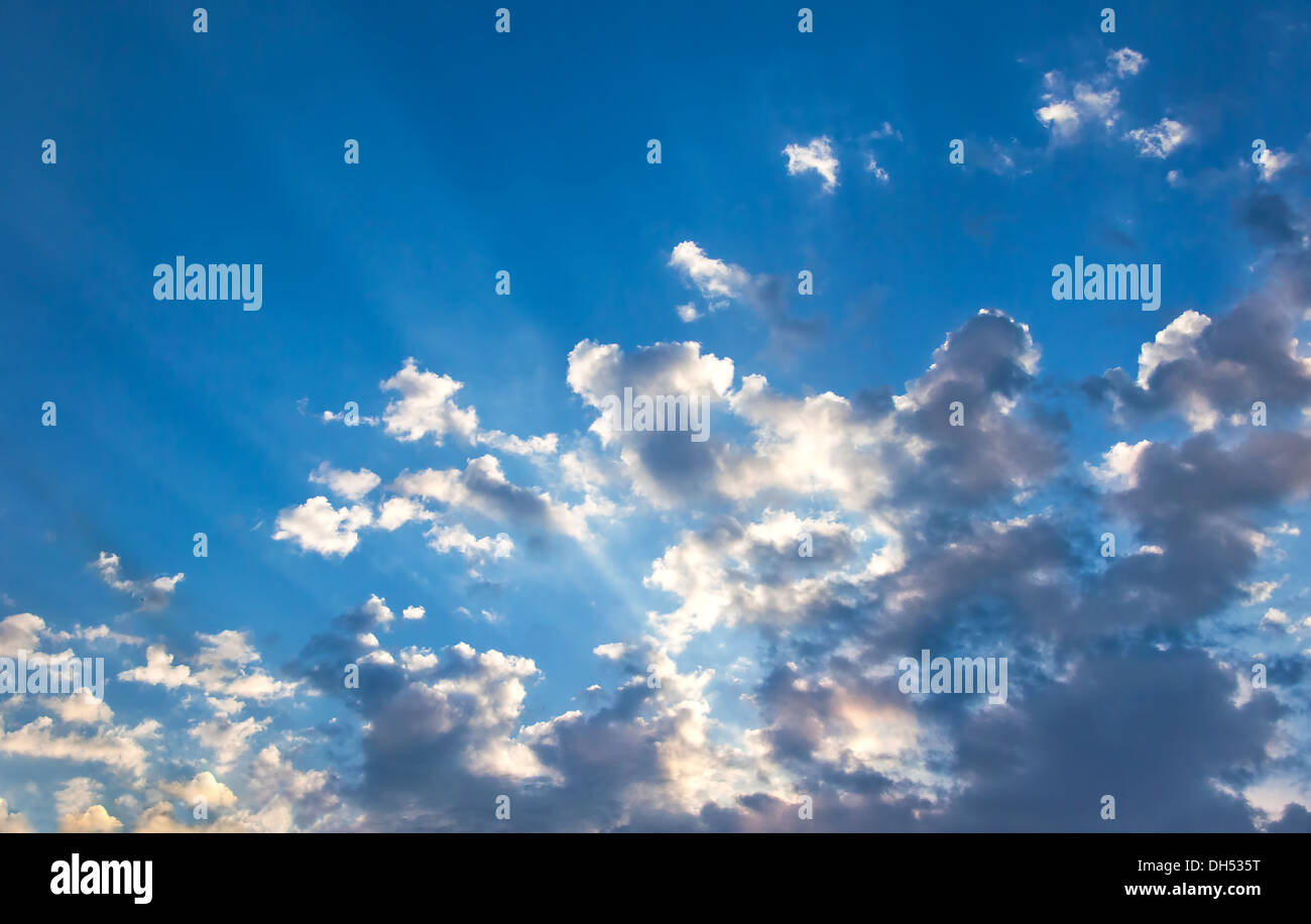 Suns rays beaming from behind clouds Stock Photo - Alamy