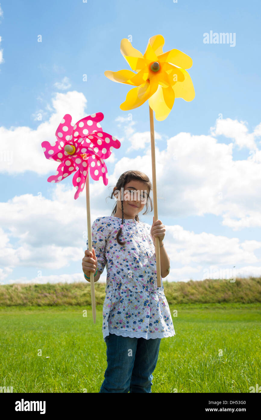 Girl with pinwheels on a meadow Stock Photo - Alamy