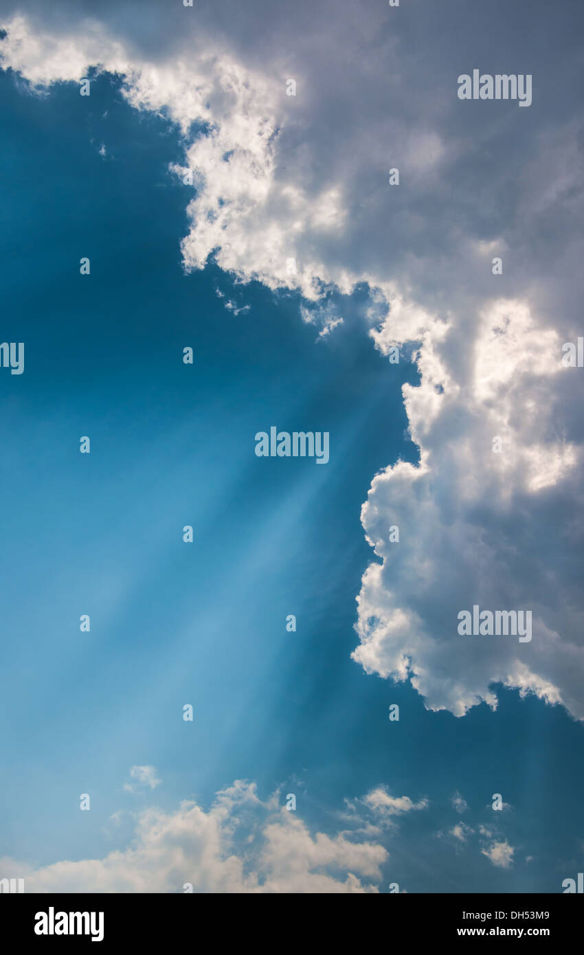 Suns rays beaming from behind clouds Stock Photo - Alamy