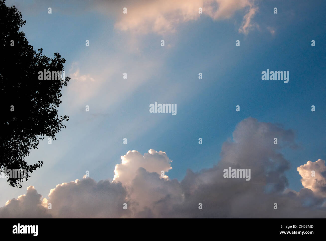 Suns rays beaming from behind clouds Stock Photo - Alamy