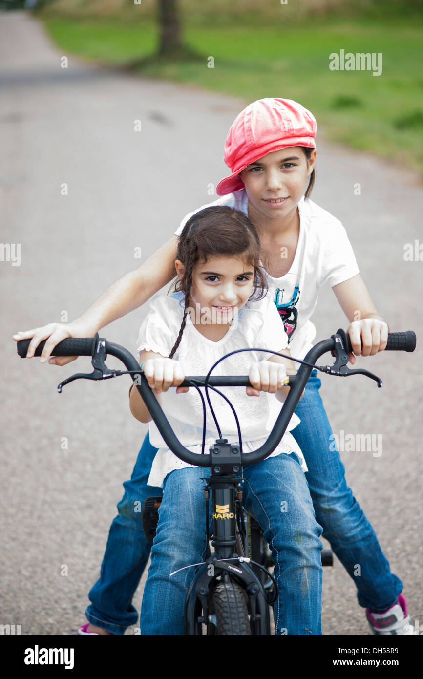 Two sisters riding on a BMX bike together Stock Photo - Alamy