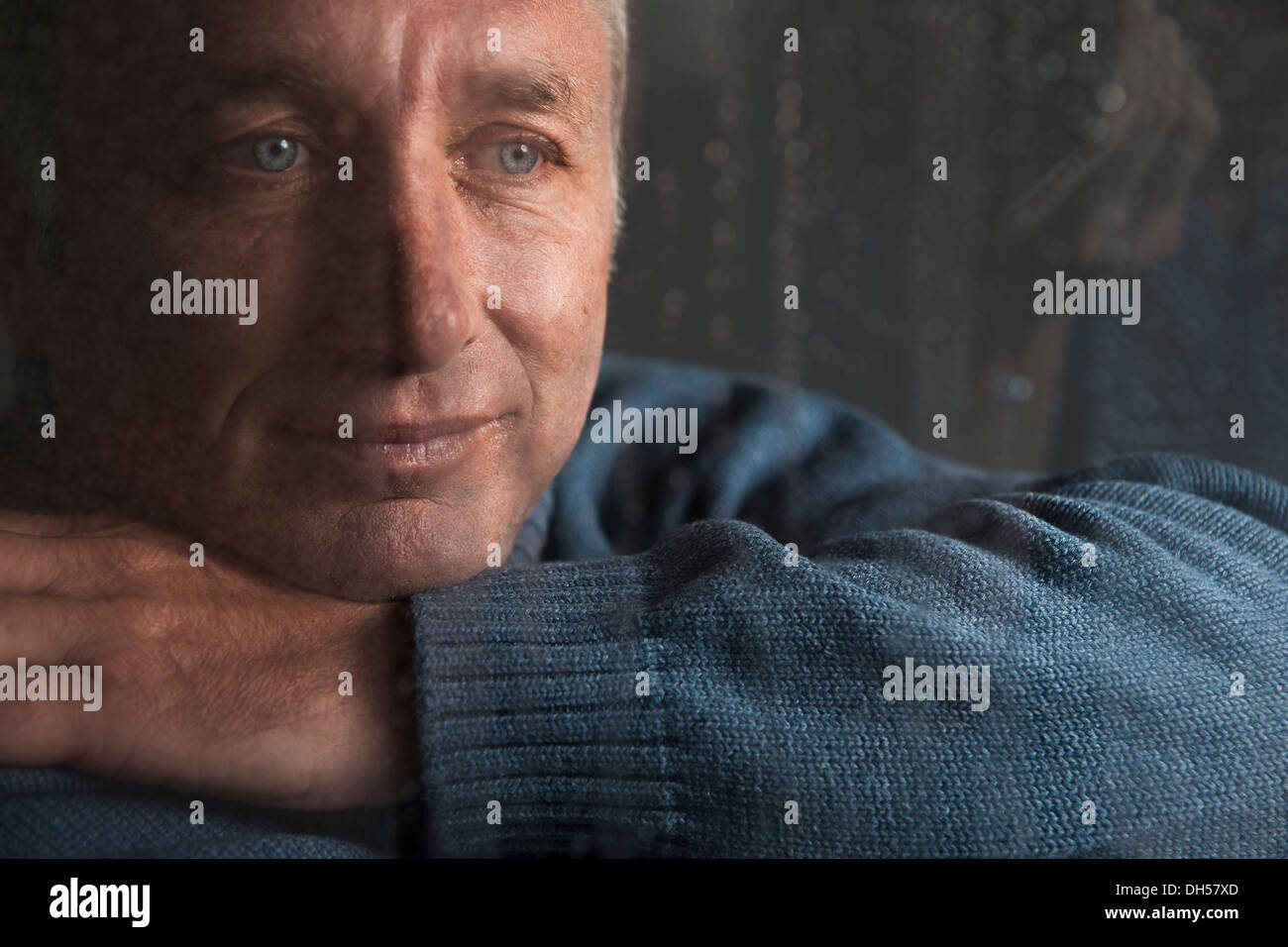 Lonely man sitting behind a window covered in rain drops, Mannheim ...
