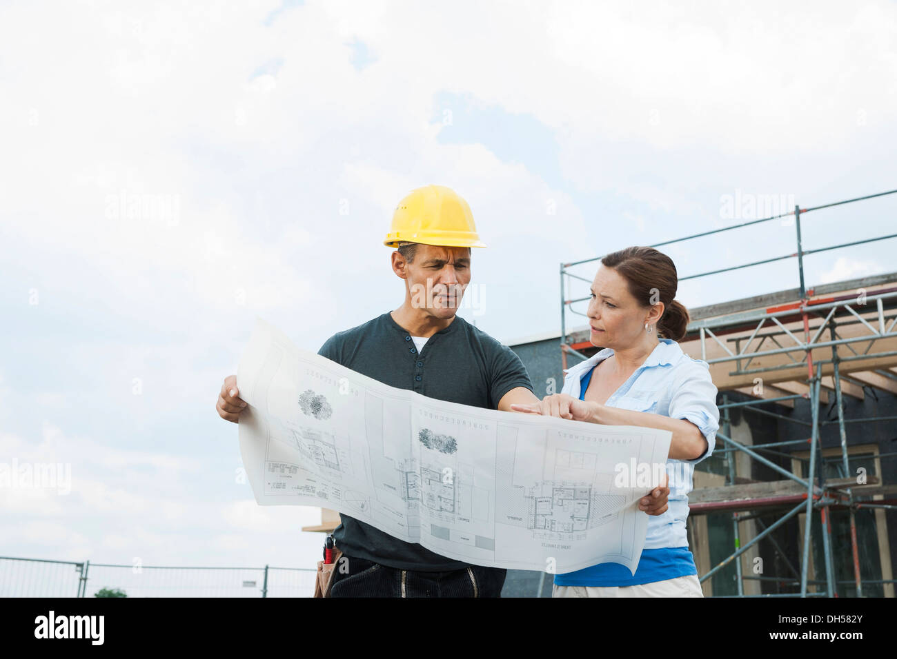 Construction manager and building owner discussing plans on a ...