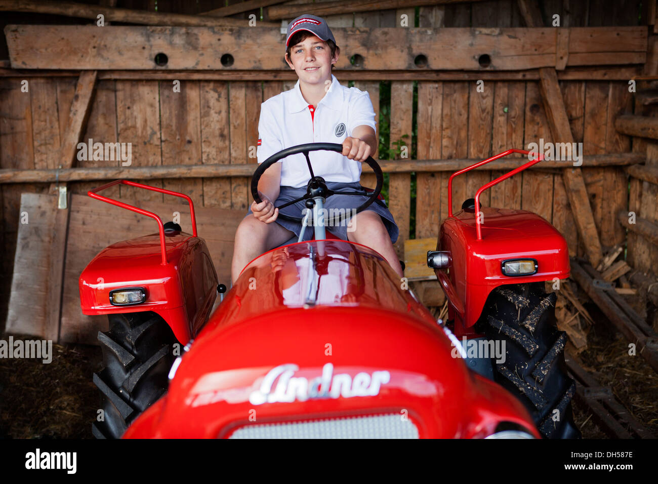 Boy sitting on a vintage tractor, Reith im Alpbachtal, Kufstein ...