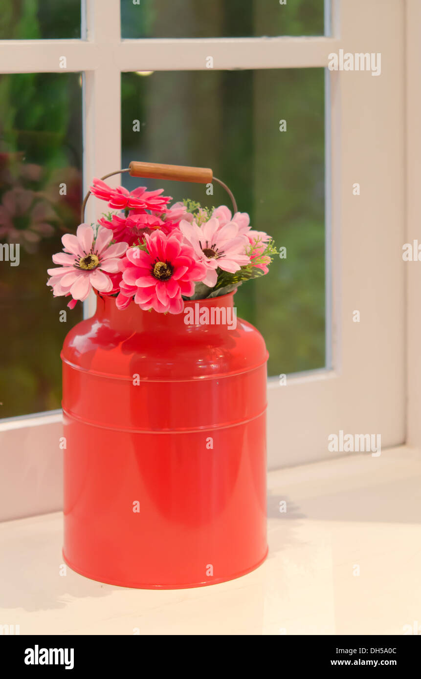 plastic flowers in red vase on table Stock Photo - Alamy