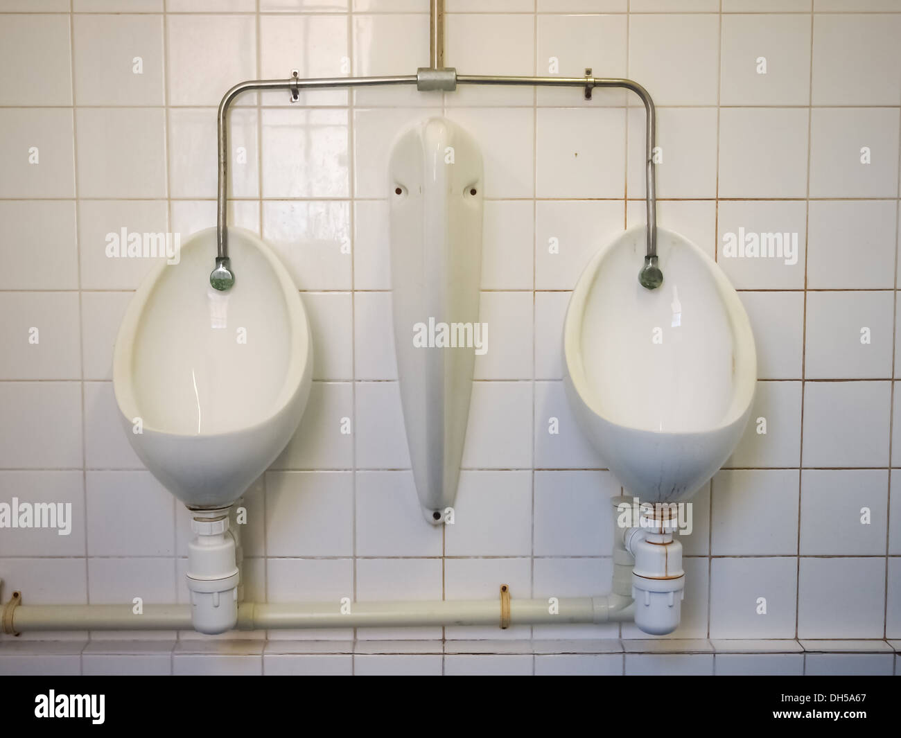 Male urinals in a public bathroom with an automated flush system Stock ...