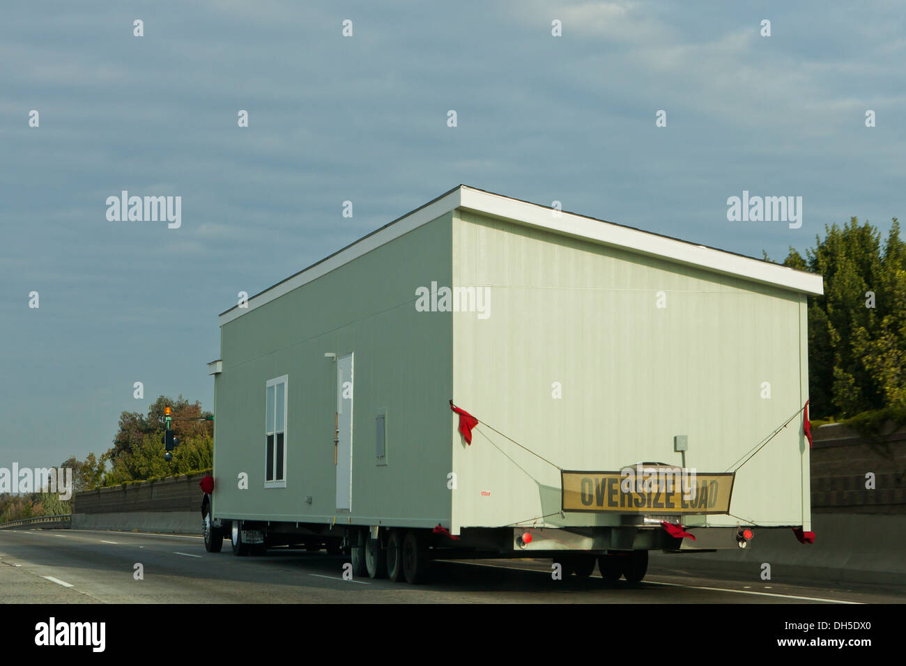 Tractor-trailer carrying trailer home on highway - California, USA ...
