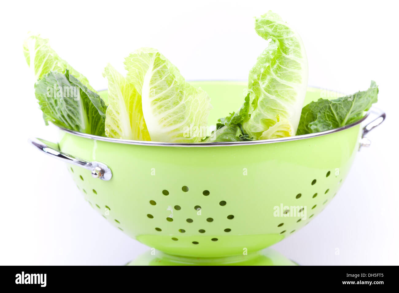 salads in green colander on white background Stock Photo - Alamy