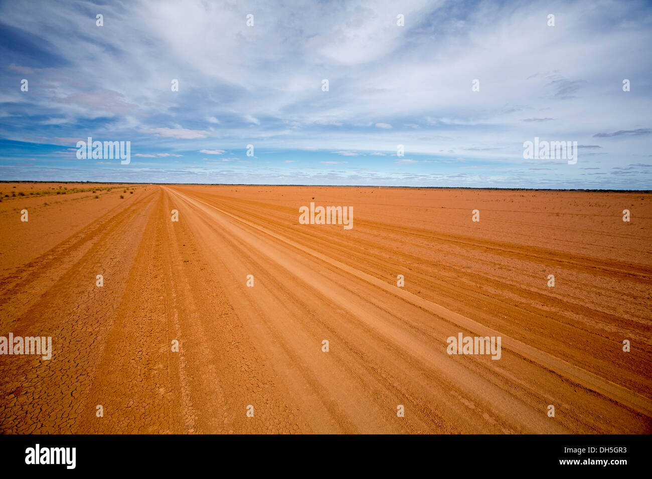 Spectacular landscape with long red road across vast barren treeless ...