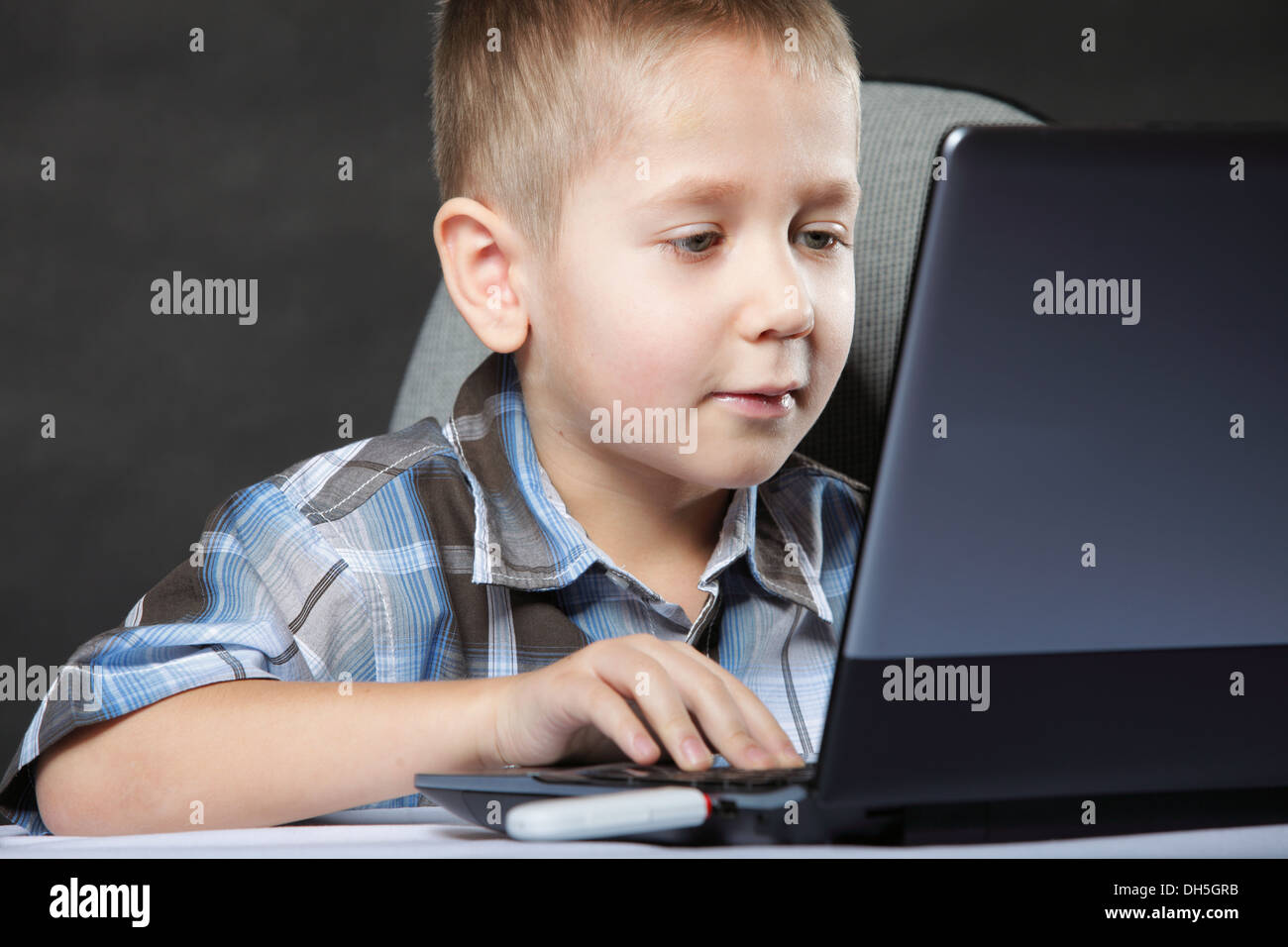 Computer addiction child boy with laptop notebook black background ...