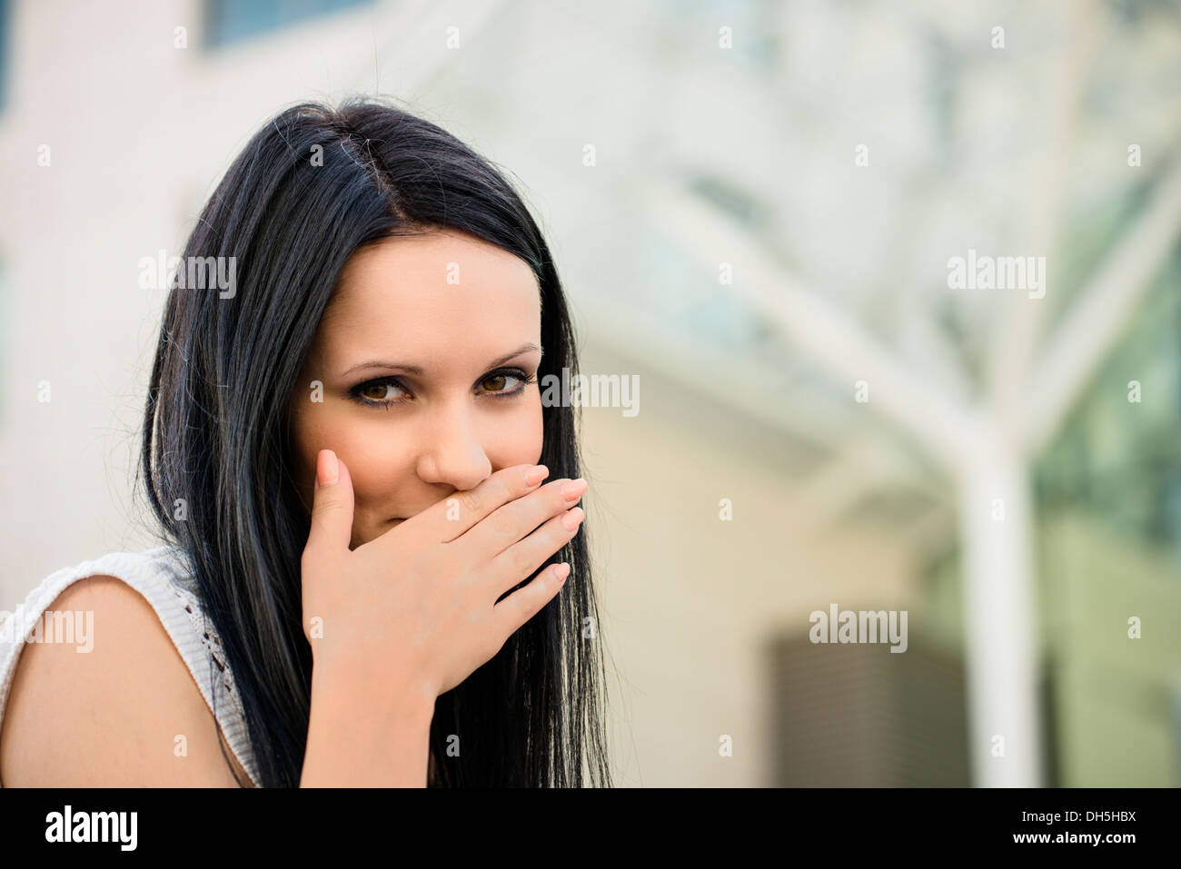 Young beautiful woman covering mouth with hand Stock Photo - Alamy