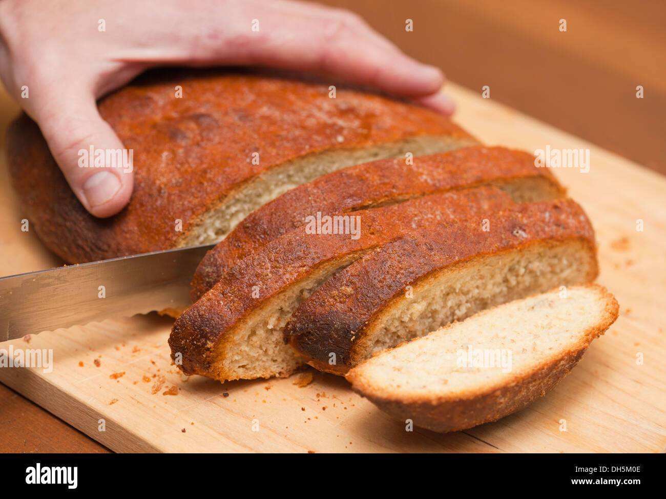 cutting freshly made bread ona wooden board Stock Photo - Alamy