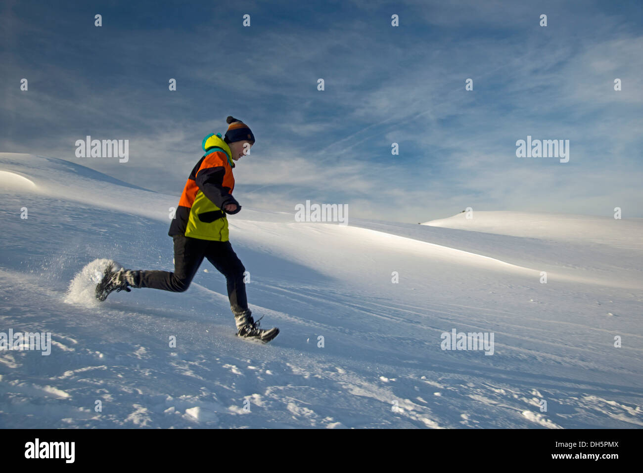 Boy, 12, running through the snow, Gottesackerplateau, Kleinwalsertal ...
