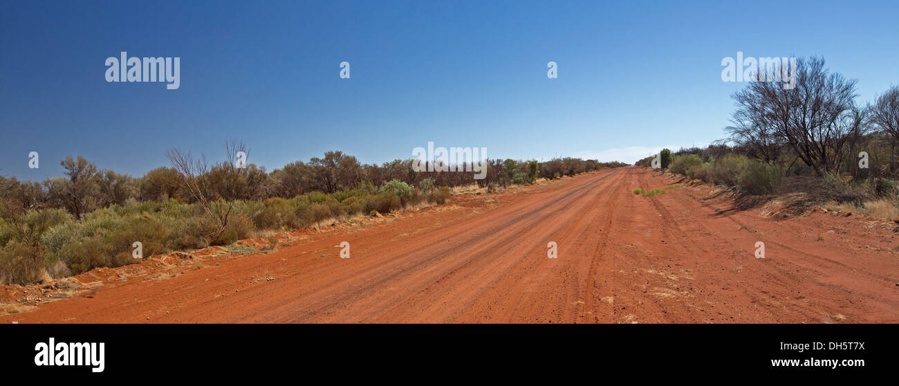 Panoramic landscape with long red dirt road of Sandover Highway slicing ...