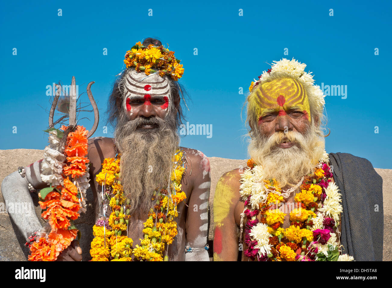 Two sadhus, holy men with a typical face painting, one holding a ...