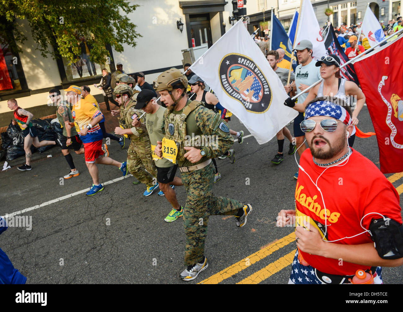 Runners with the Special Operations Warrior Foundation carry flags ...