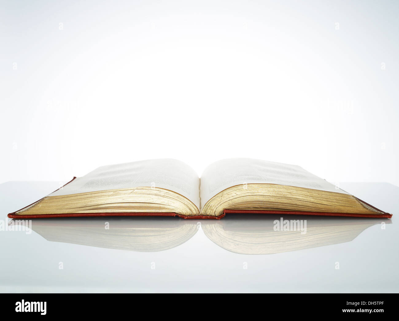 open gilt edge bound book on a white background Stock Photo - Alamy