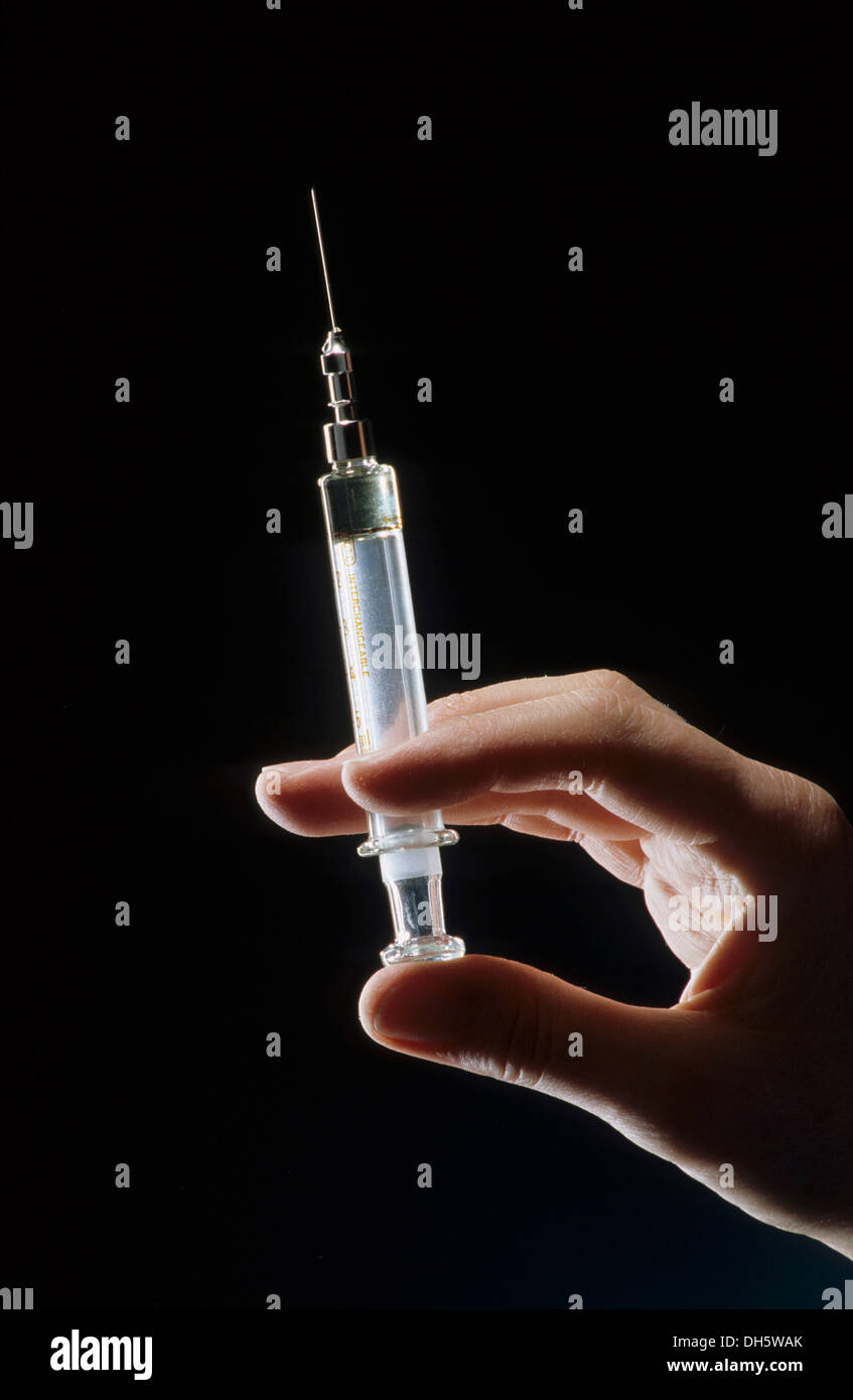 Hand holding syringe Stock Photo - Alamy