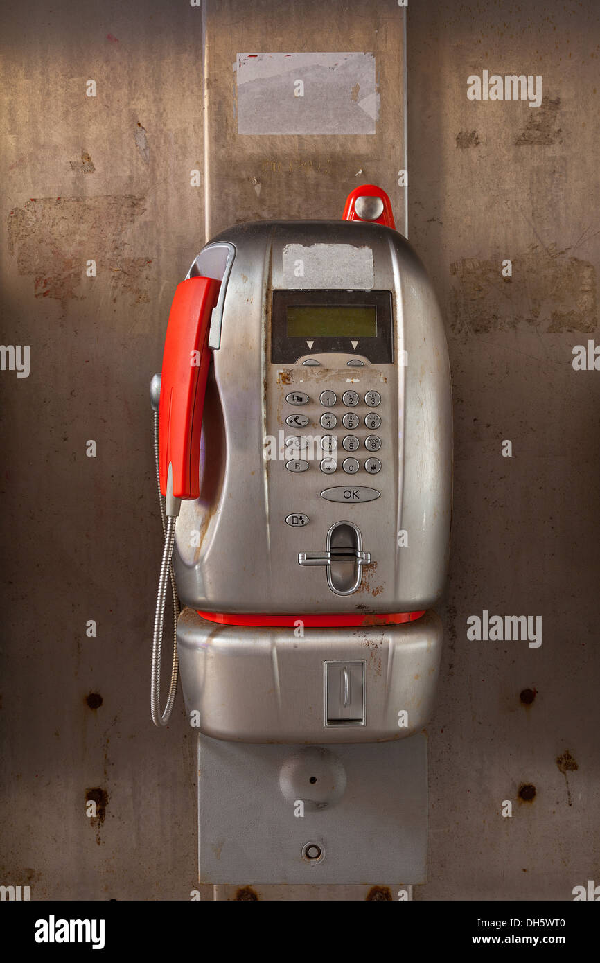 Aluminium public telephone with a red handset Stock Photo - Alamy