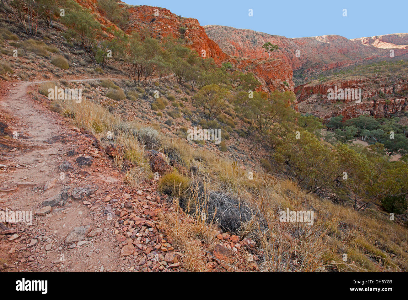 Australian outback landscape with pathway across rugged red rocky hills ...