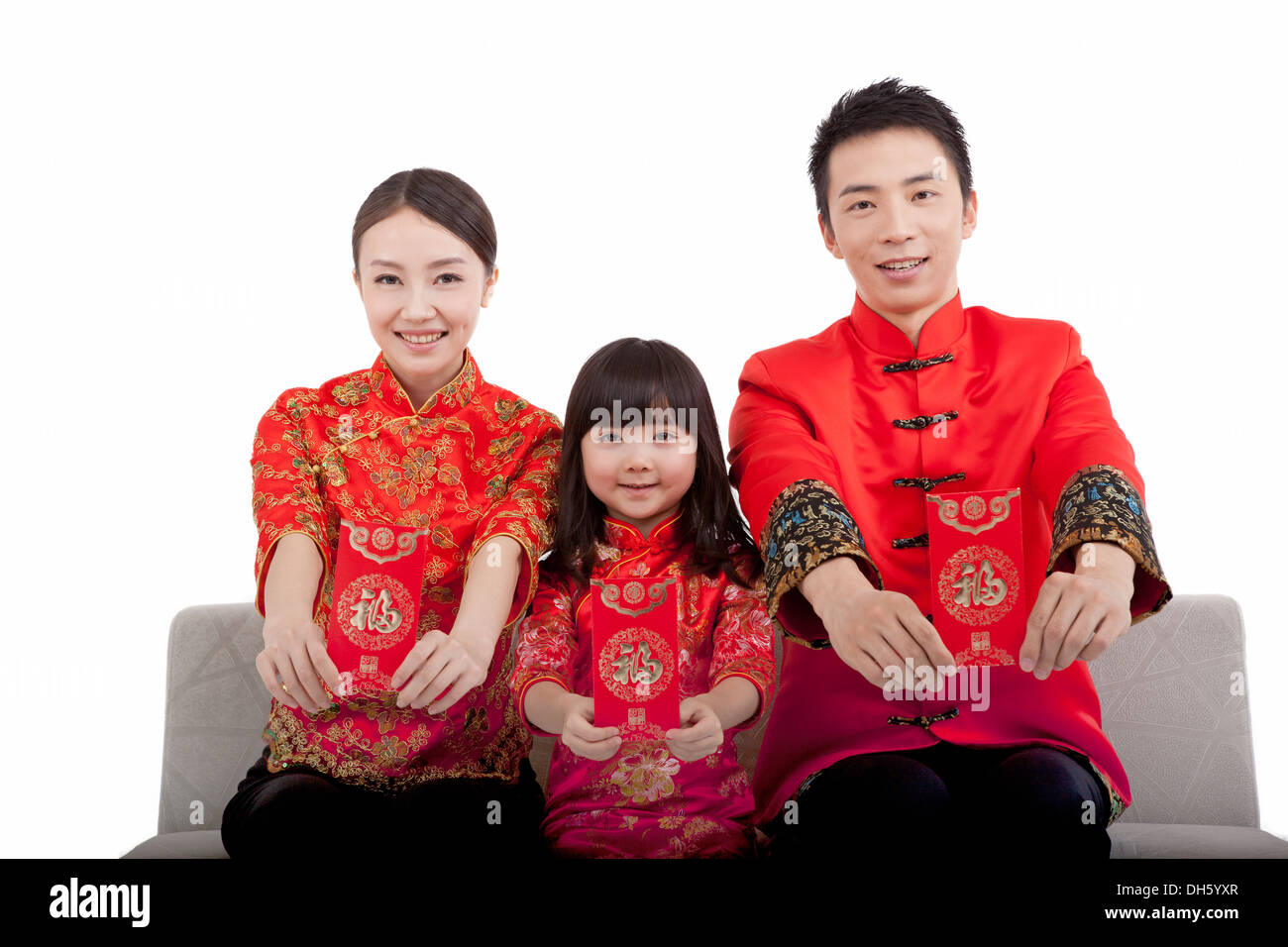 Family of three wearing costume and red envelope Stock Photo - Alamy
