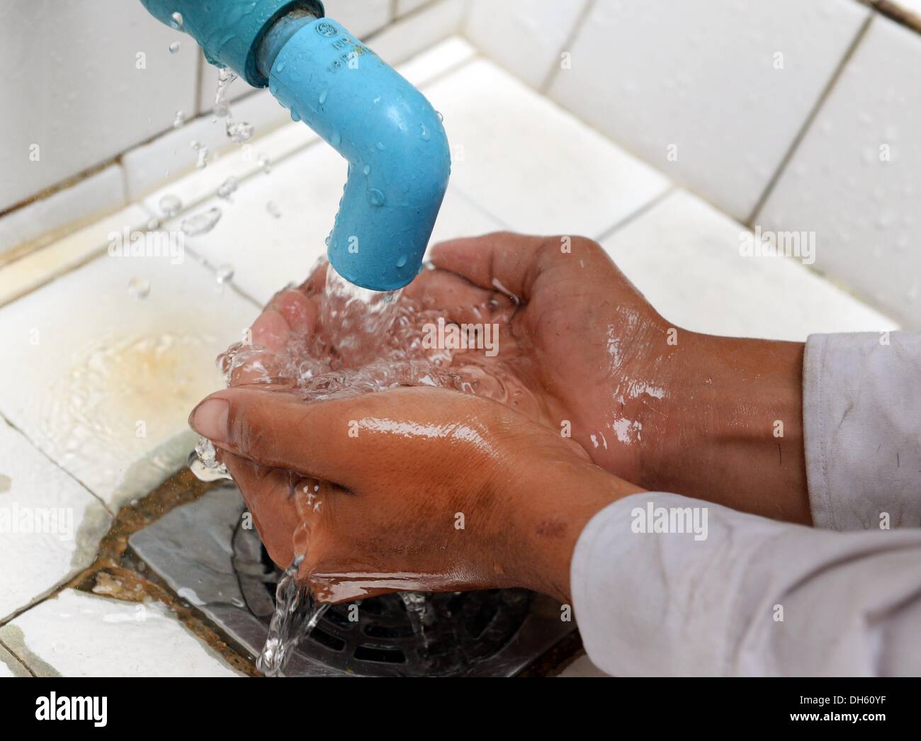 Phnom Penh, Cambodia. 10th Oct, 2013. A child takes water from a tap in ...