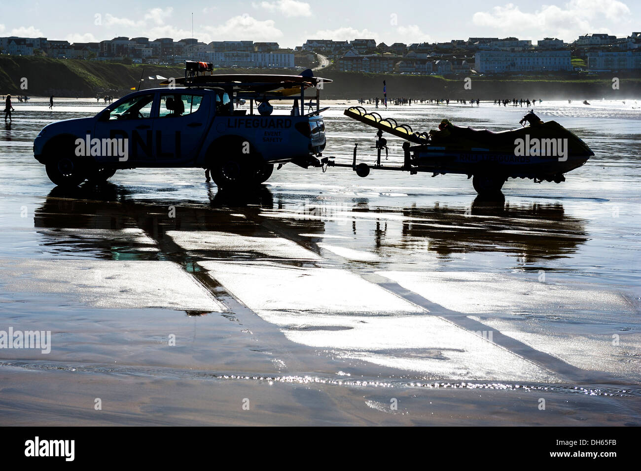 The silhouette of a RNLI Lifeguard truck and trailer parked on Fistral ...
