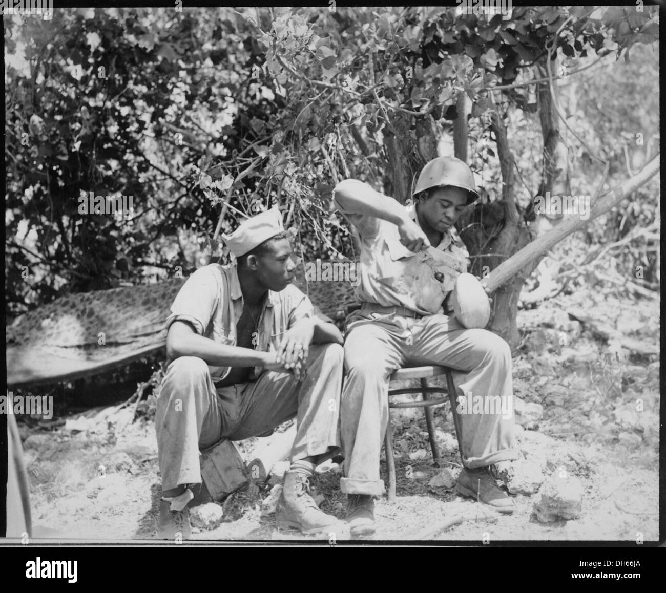 Marine Sergeant F. Smit and Corporal S. Brown open a coconut to get a ...