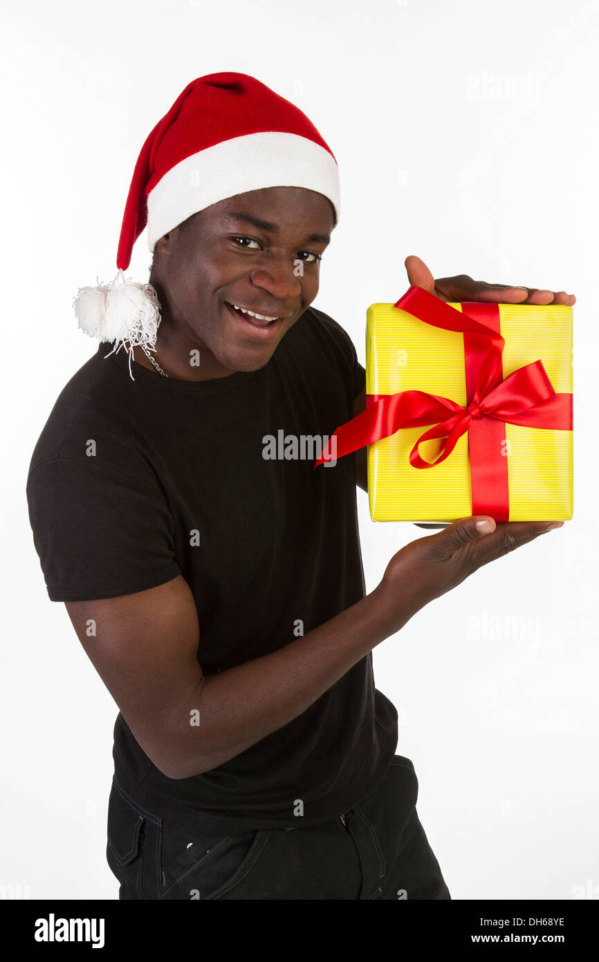 Young black man wearing a Santa hat and holding a present Stock Photo ...