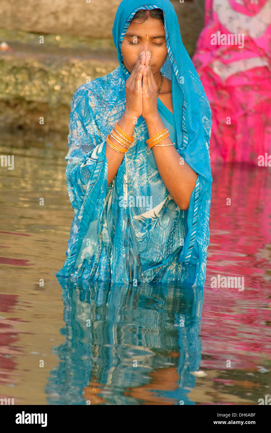 Indian woman praying for the dead, Ganges river, holy, Varanasi, India ...