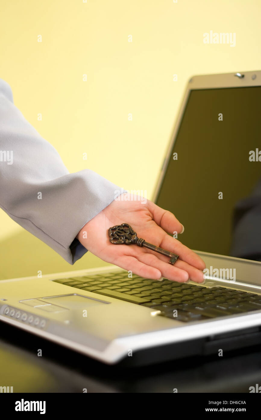 Hand showing the key to success in front of a laptop computer Stock ...