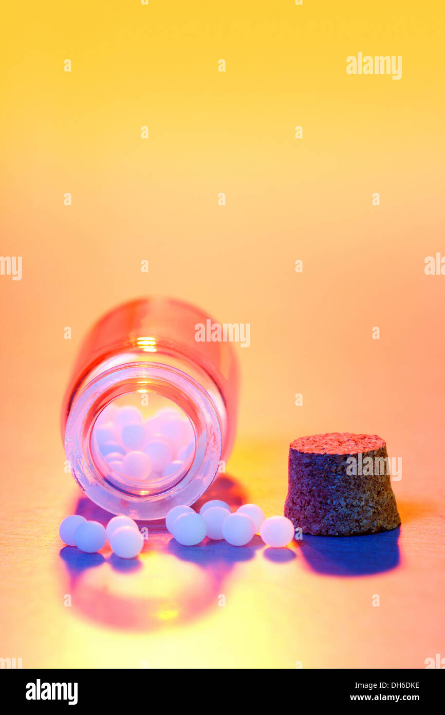 Close view of homeopathic medication in colored light - small white ...