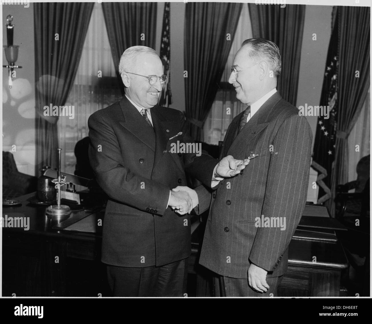 President Truman is seen presenting the Distinguished Service Medal to ...