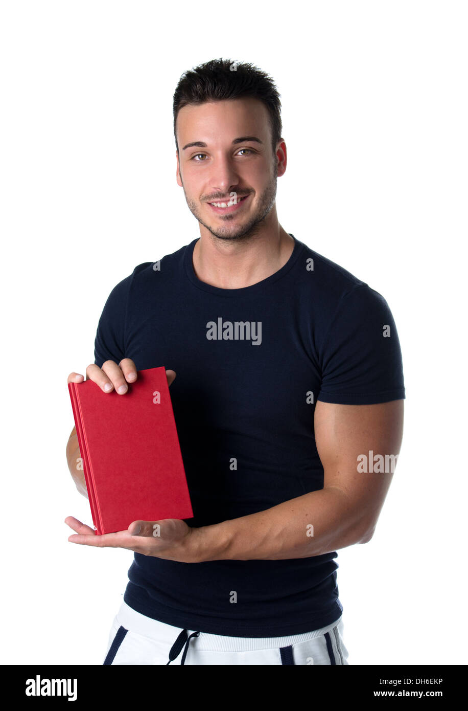 Smiling young man holding and showing book cover and looking in camera ...