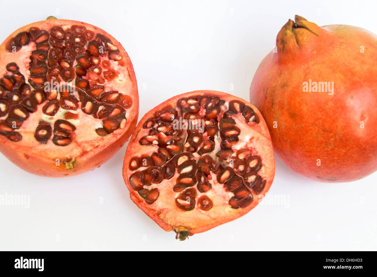 Red, juicy seeds visible on half-cut pomegranate fruit, isolated on ...