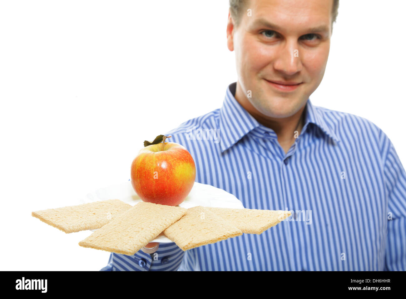 Smiling man in blue shirt offering healthy nutrition, apple and crisp ...
