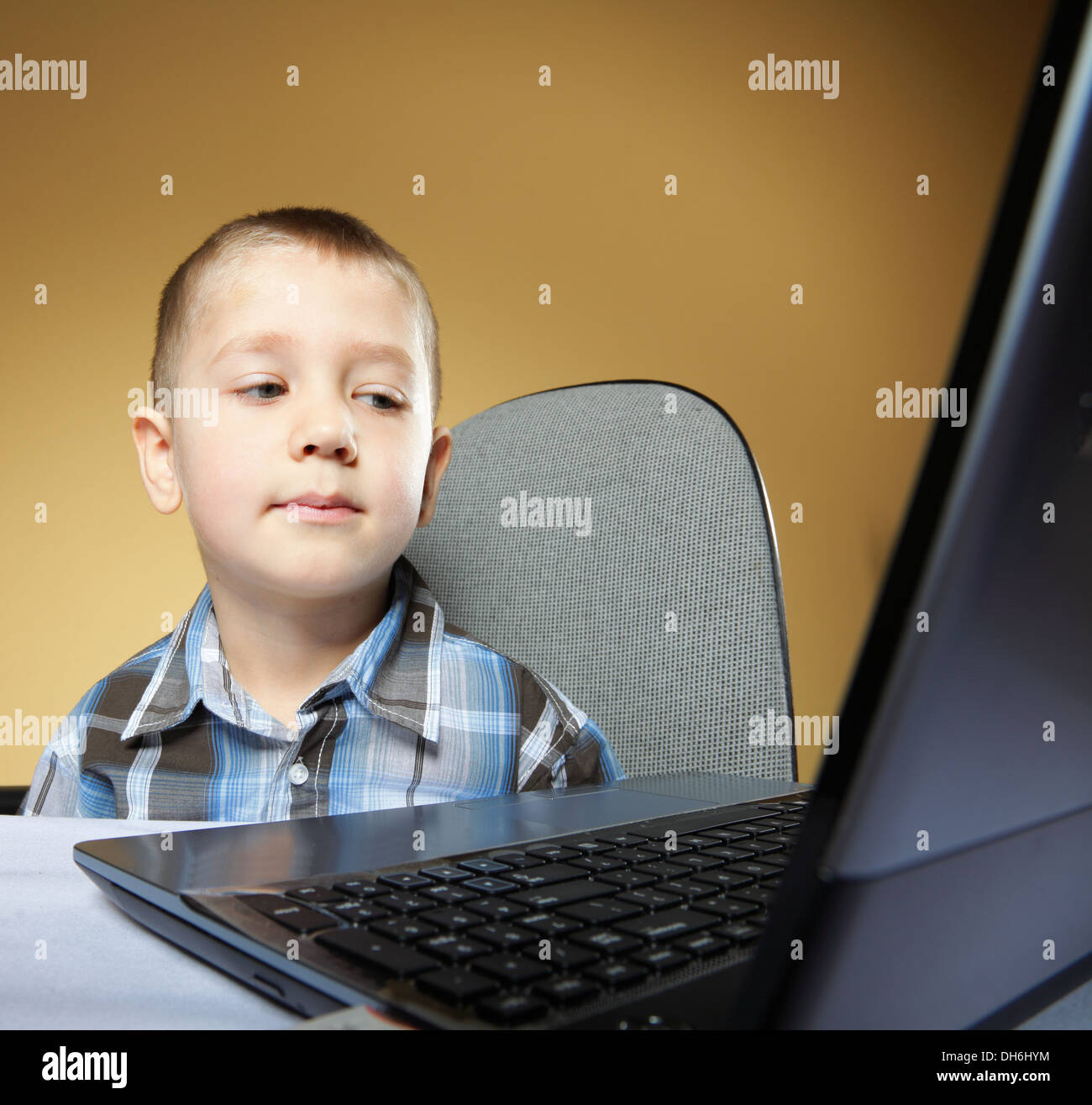 Computer addiction child boy with laptop notebook brown background ...