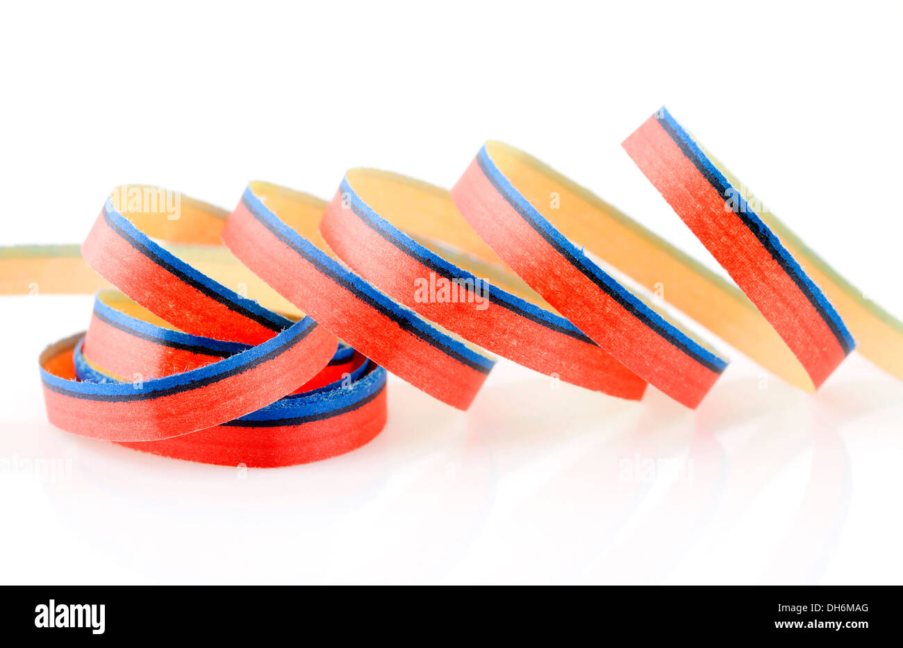Curly party streamer in closeup over white background Stock Photo - Alamy