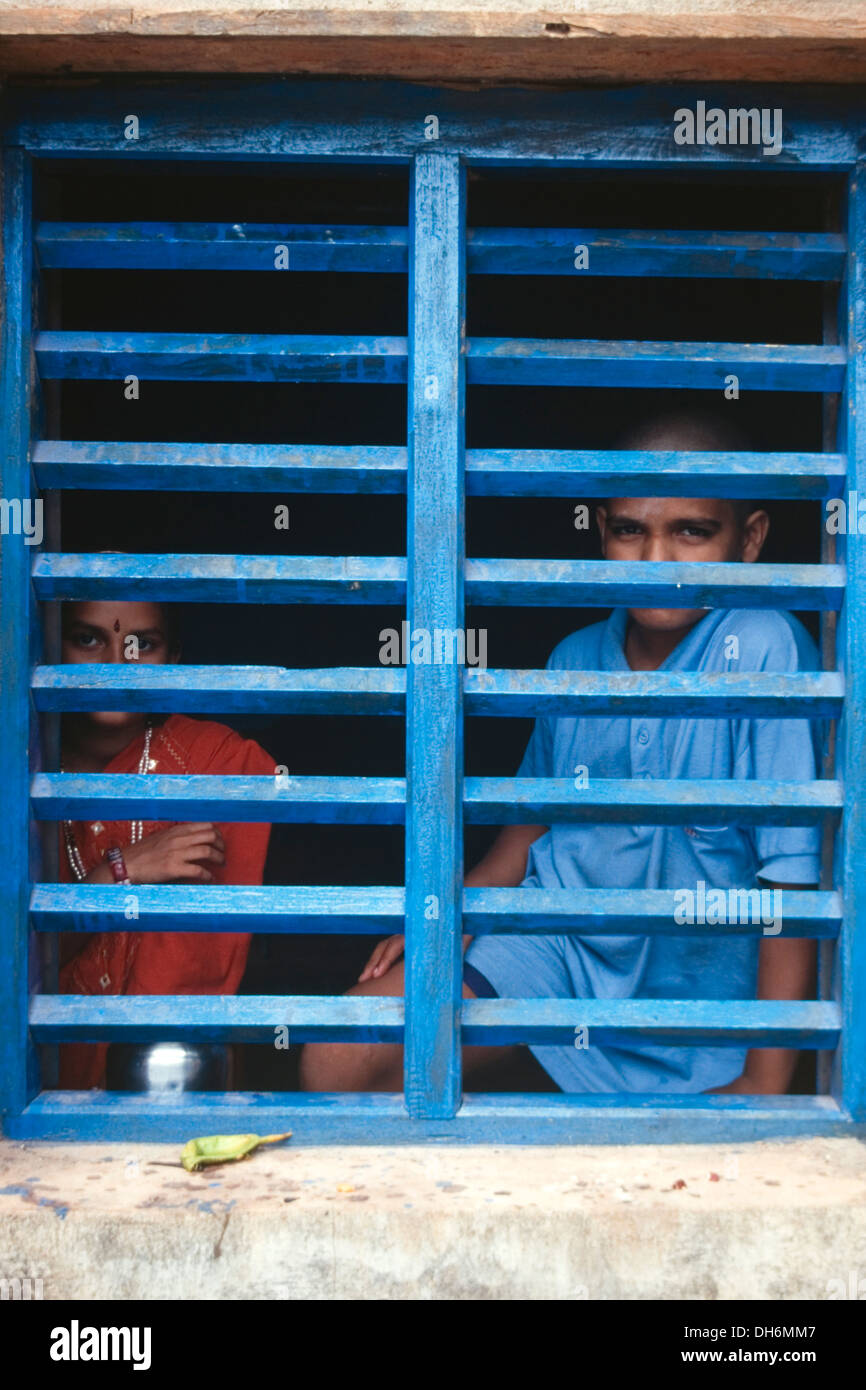 two people looking out through barred window india Stock Photo - Alamy