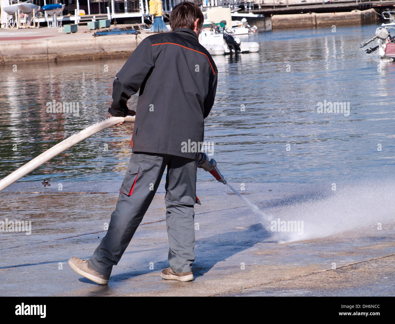 man with water pump clean working platform Stock Photo - Alamy