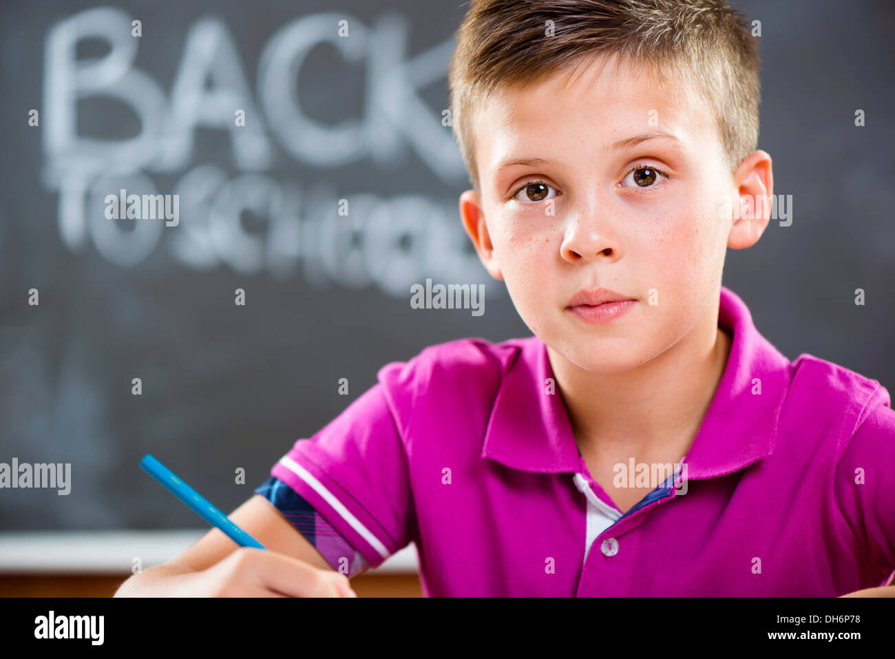 Cute school boy studying in classroom foreground blackboard Stock Photo ...