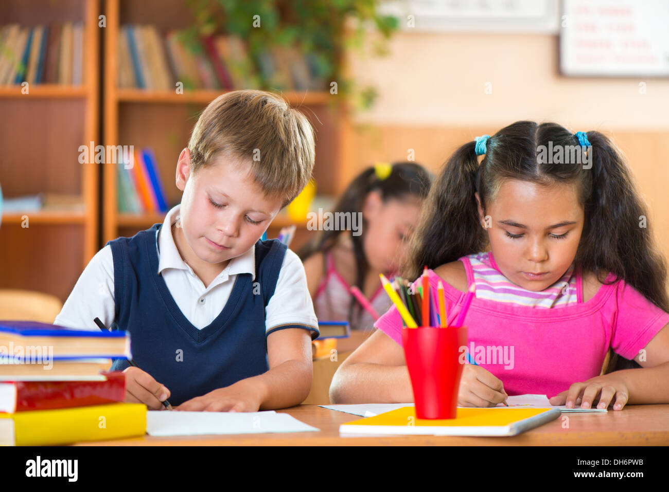 Cute schoolchildren during lesson in classroom at school Stock Photo ...