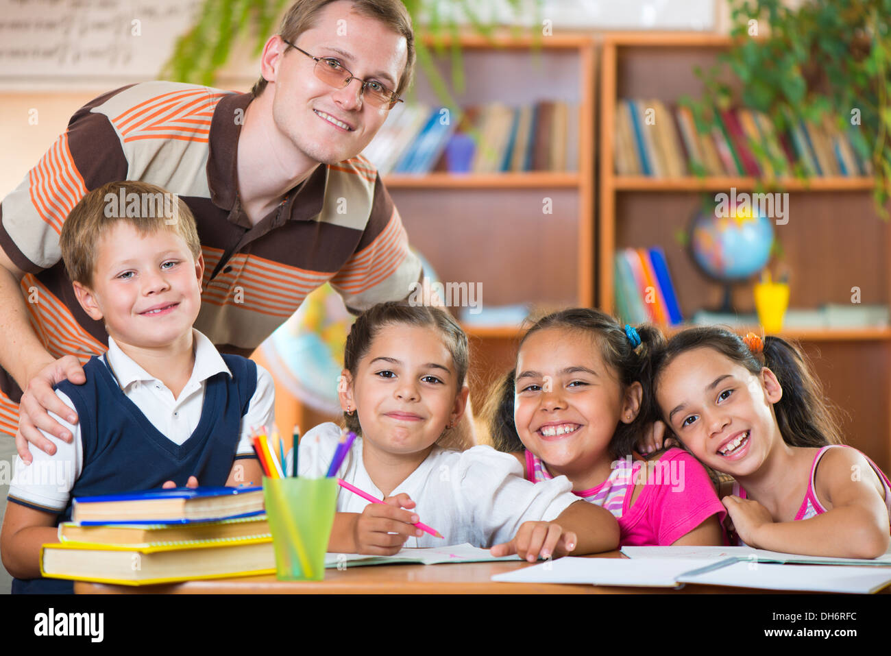 Group of elementary pupils in classroom with teacher Stock Photo - Alamy