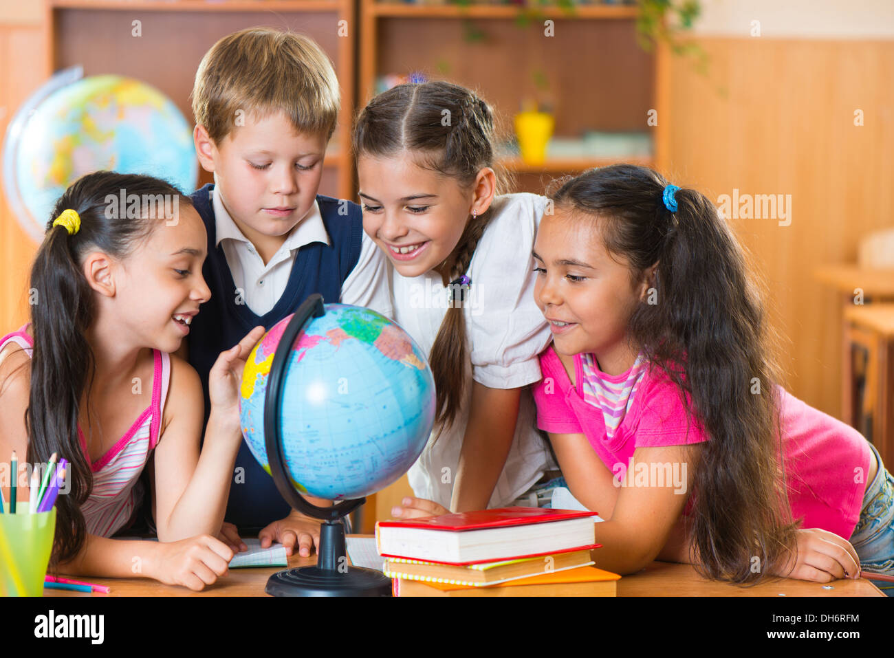 Portrait of cute schoolchildren looking at globe in classroom Stock ... Portrait of cute schoolchildren looking at globe in classroom Stock ...