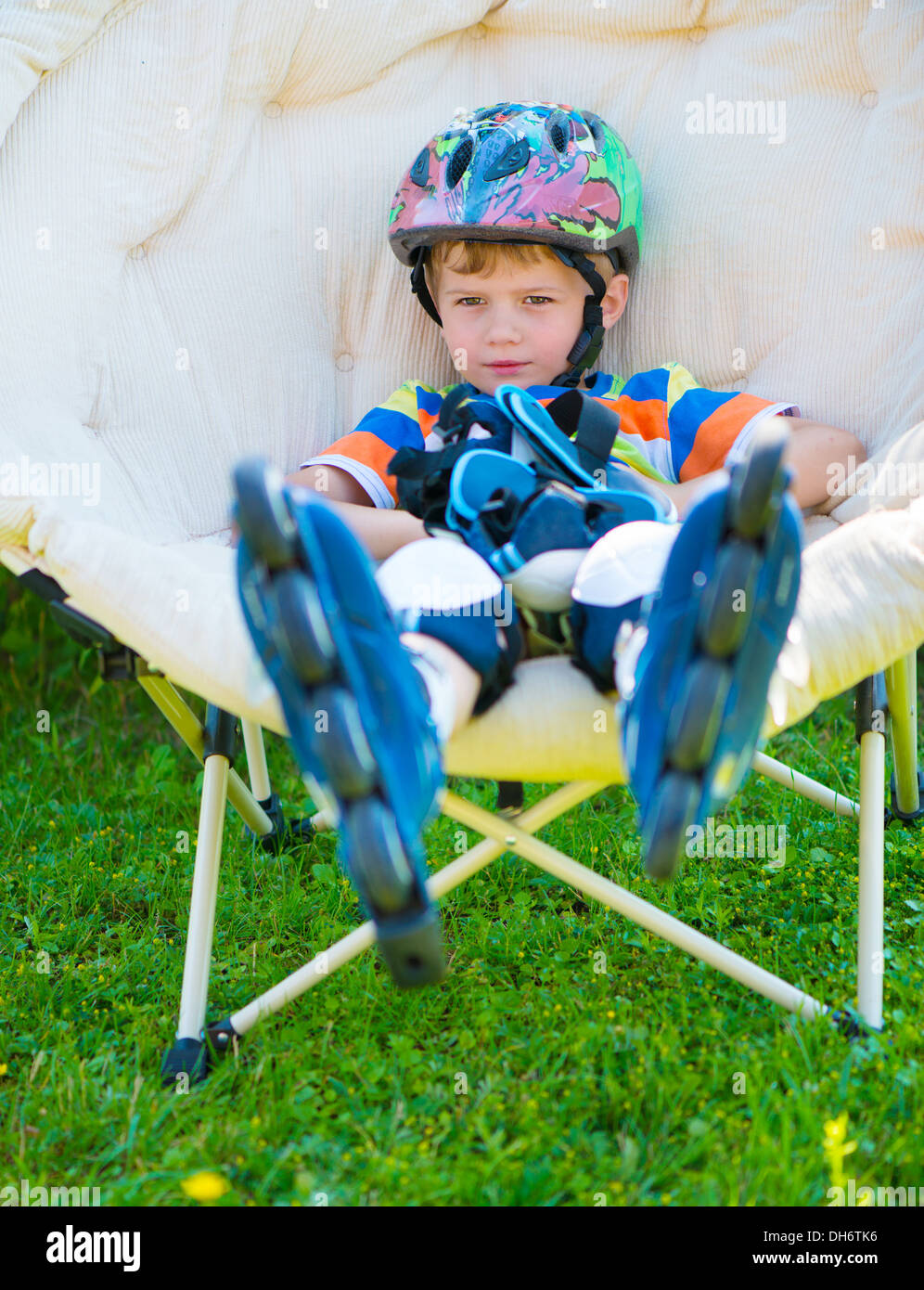 Cute little boy resting in armchair with rollers Stock Photo - Alamy