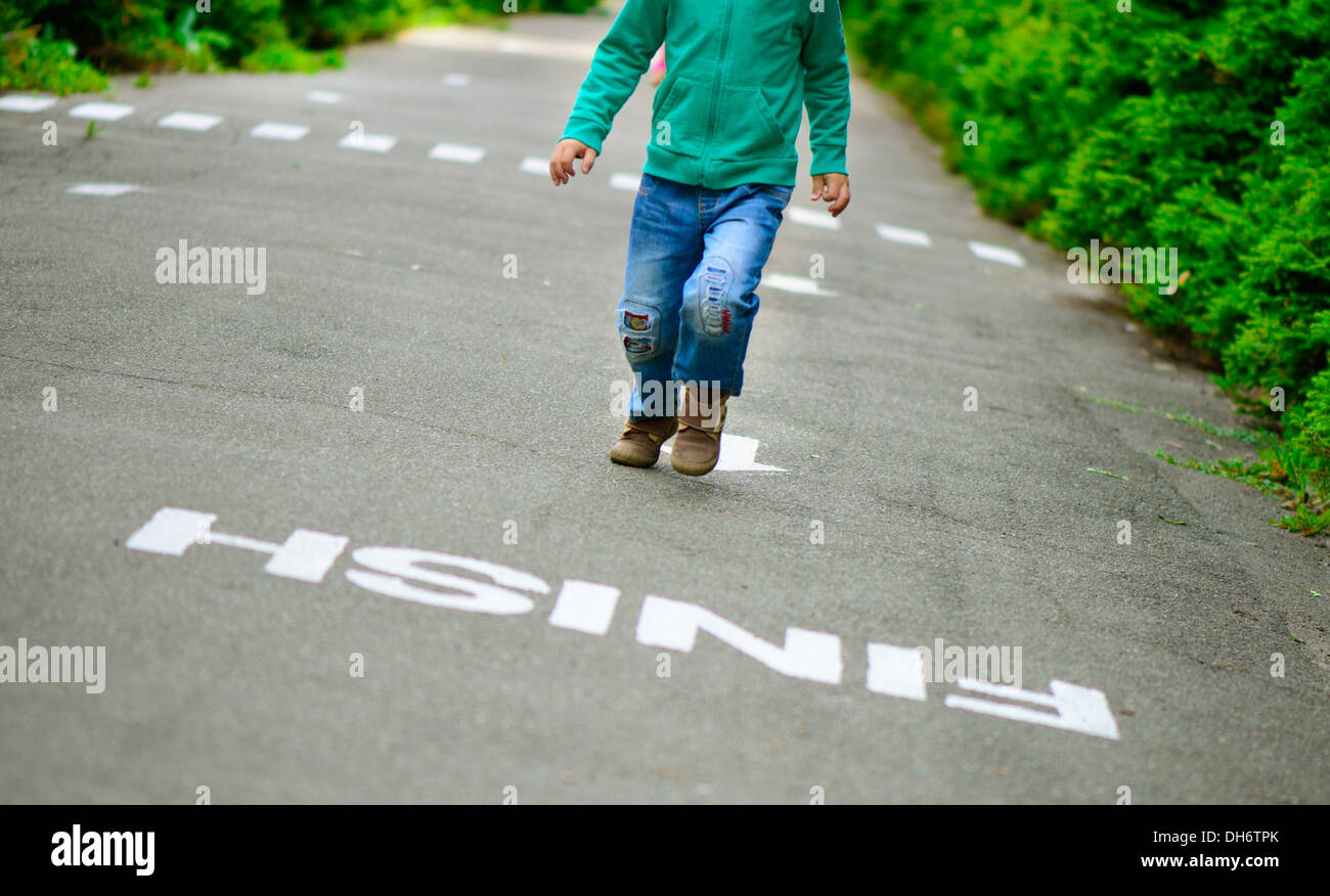 Little boy running on footpath to the finish line Stock Photo - Alamy