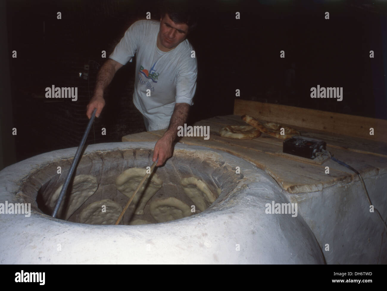 Baking Georgian bread (tonis puri) in the traditional tone oven in ...