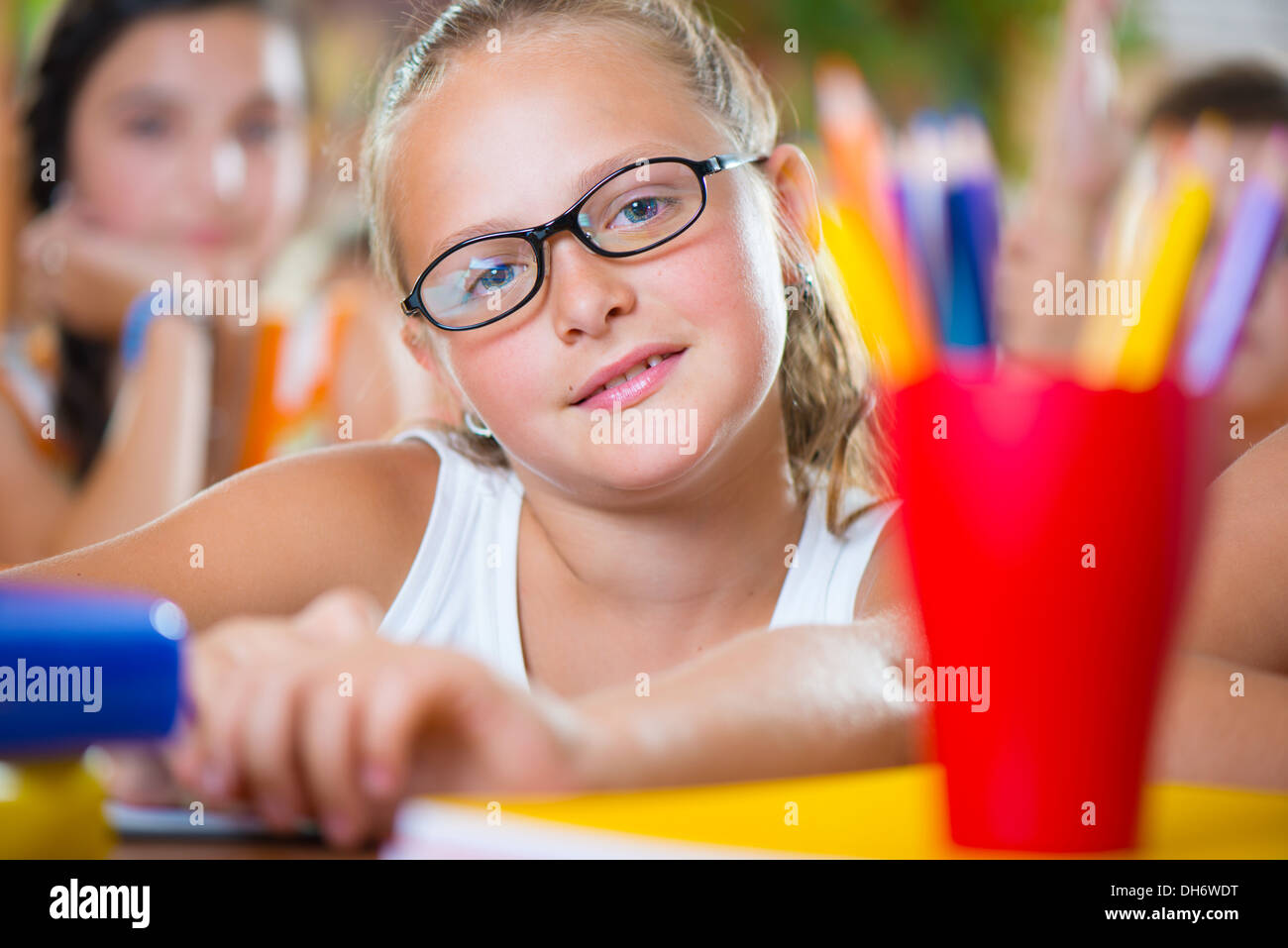 Portrait of beautiful schoolgirl girl studying in classroom at school ...