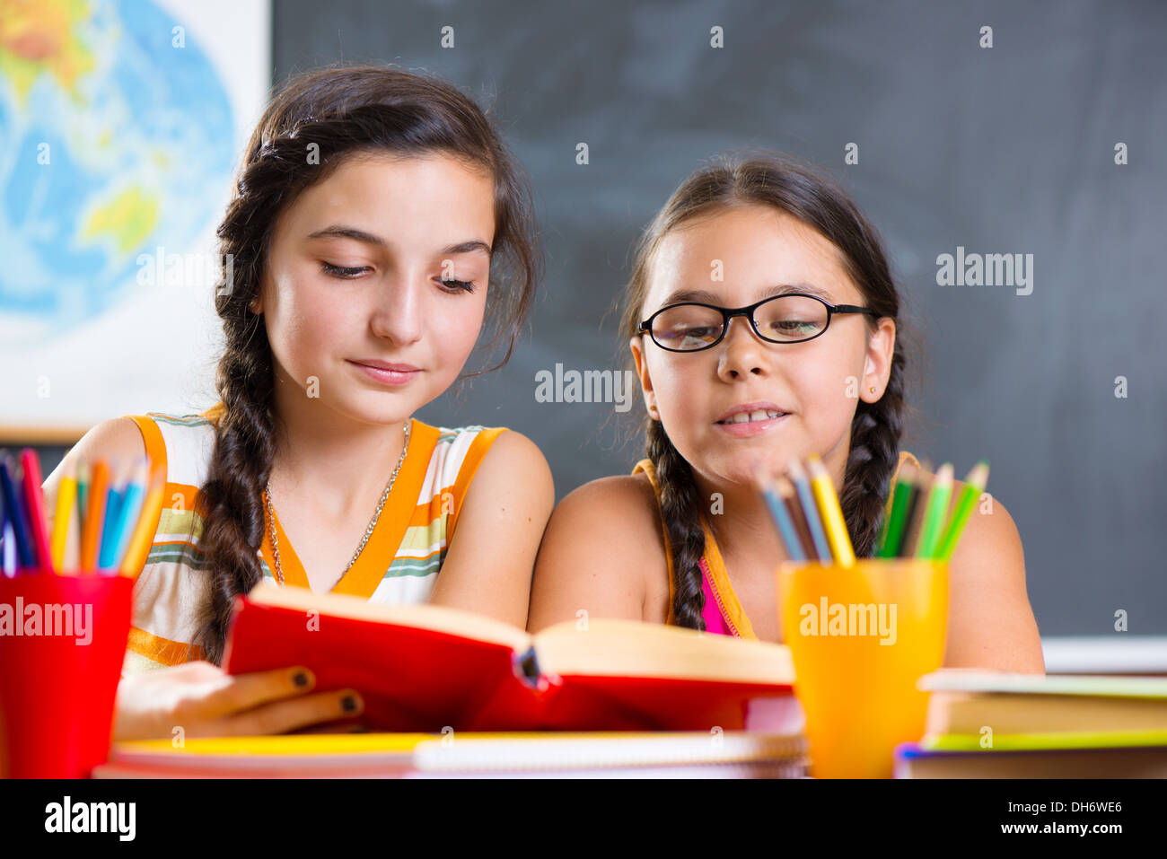 Portrait of two beautiful schoolgirl studying in classroom Stock Photo ...