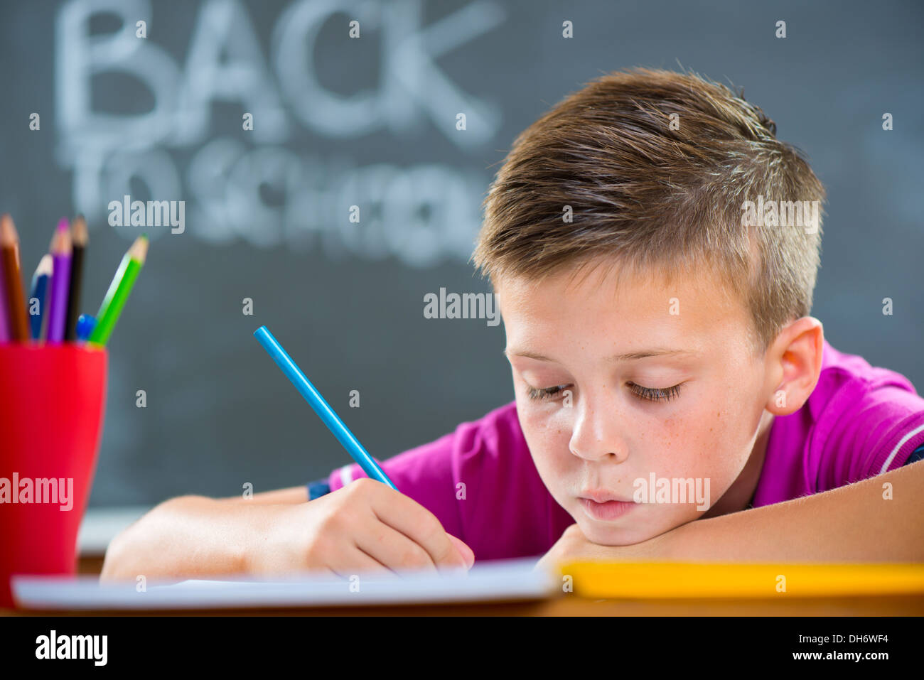 Cute school boy studying in classroom foreground blackboard Stock Photo ...